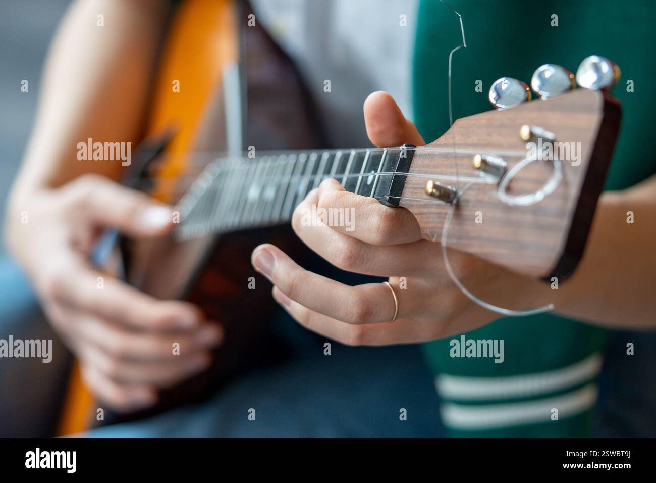 Musician hands adjusting frets on balalaika, tuning tone, playing ...