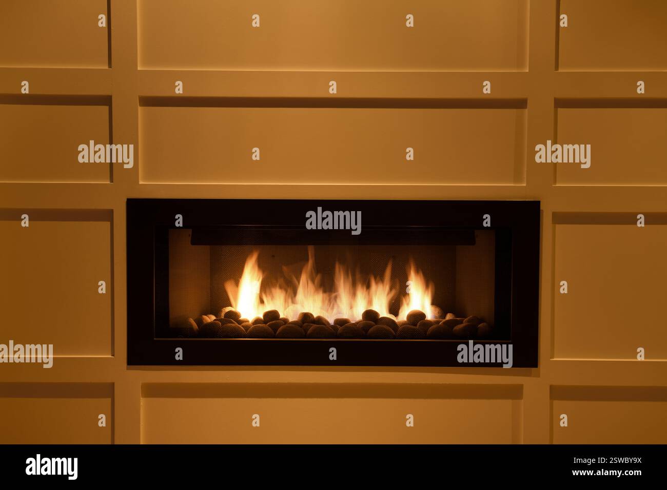 Interior gas fireplace with wall wood panelling at night Stock Photo ...