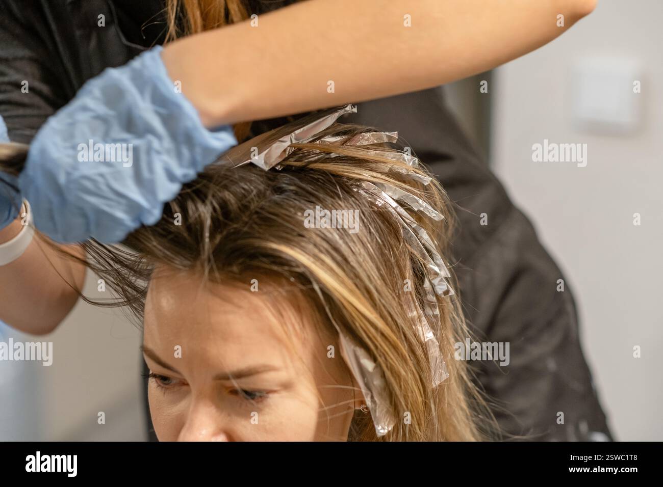 Hair coloring process in a salon with foil application during a clients ...