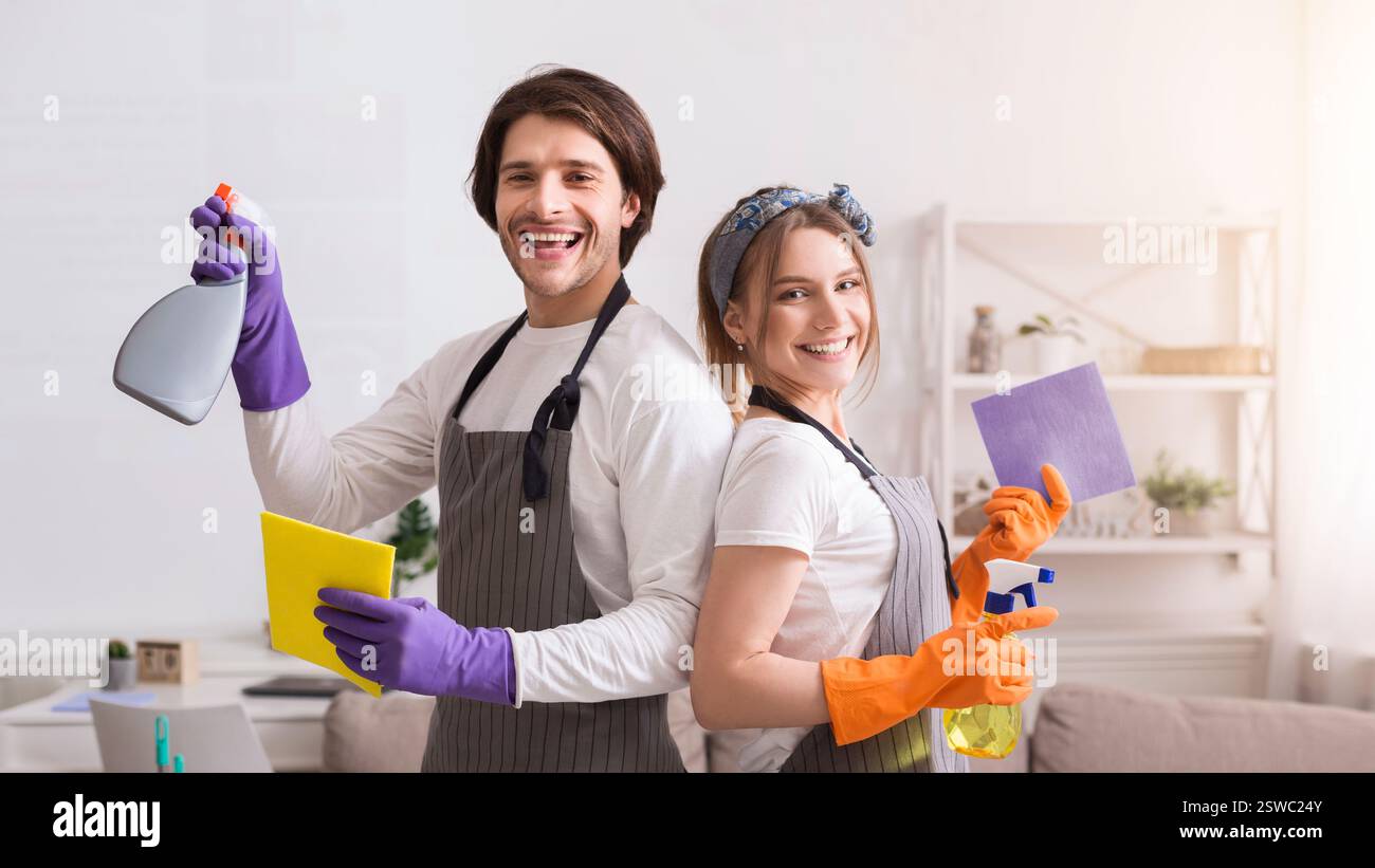 Cleaning service professionals. Joyful millennial couple holding ...