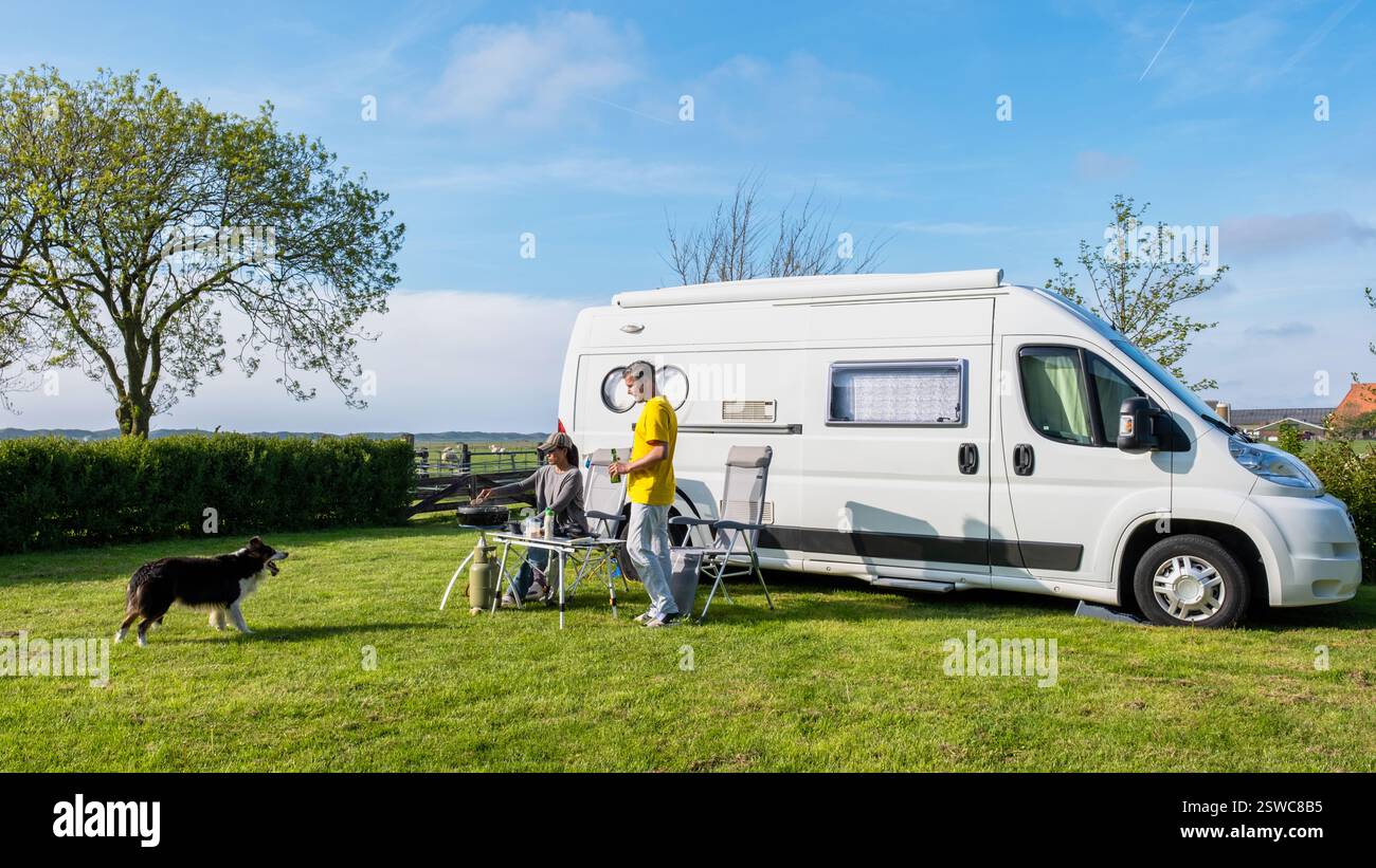 A man and his faithful dog stand next to an RV or camper van in a ...