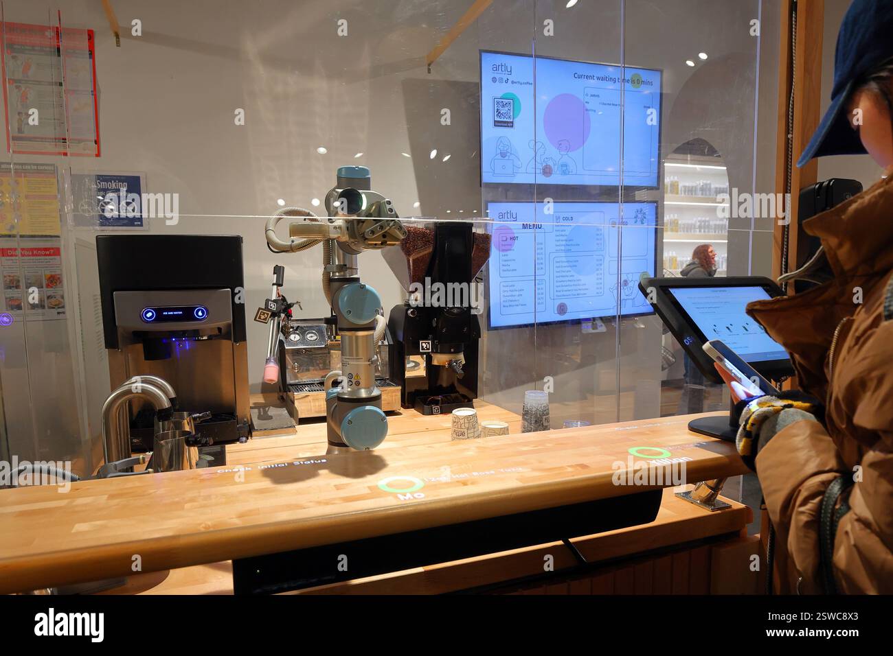 A person at an Artly automated coffee kiosk at a Muji Japanese home ...