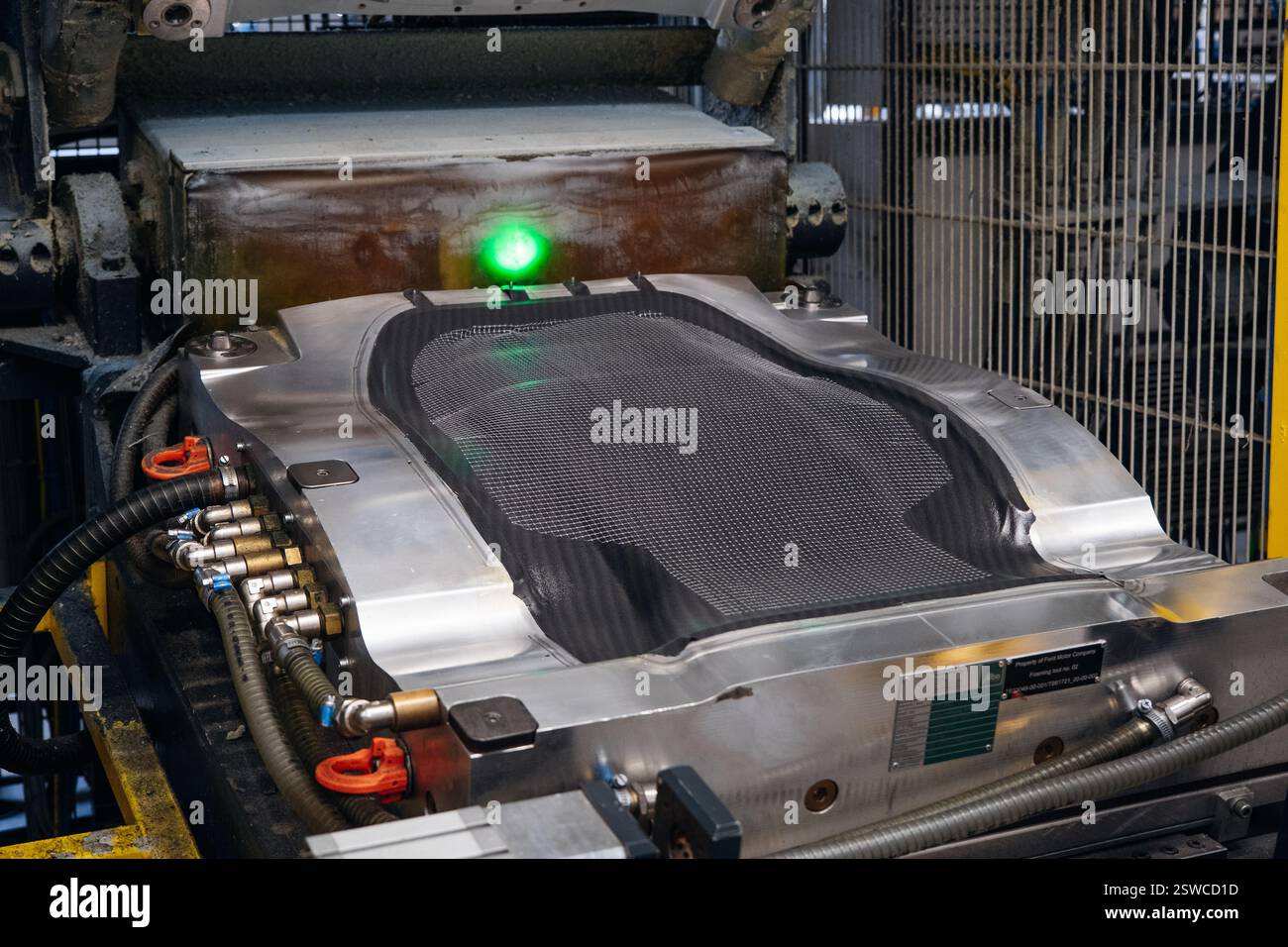 Industrial machinery forming carbon fiber with a bright green laser ...