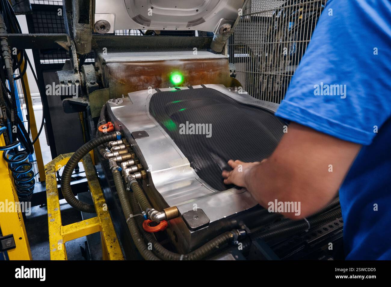 Worker using an industrial machine to form a component potentially in a ...