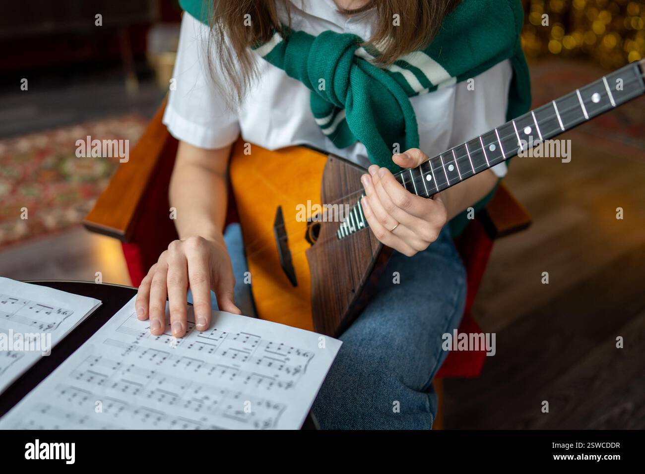 Woman hand flips through sheet music for balalaika. Ethnic musical ...