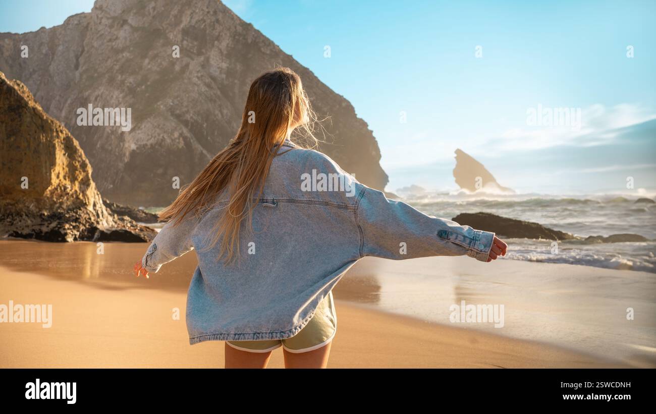 Anonymous woman in denim shirt standing with arms outstretched on ...