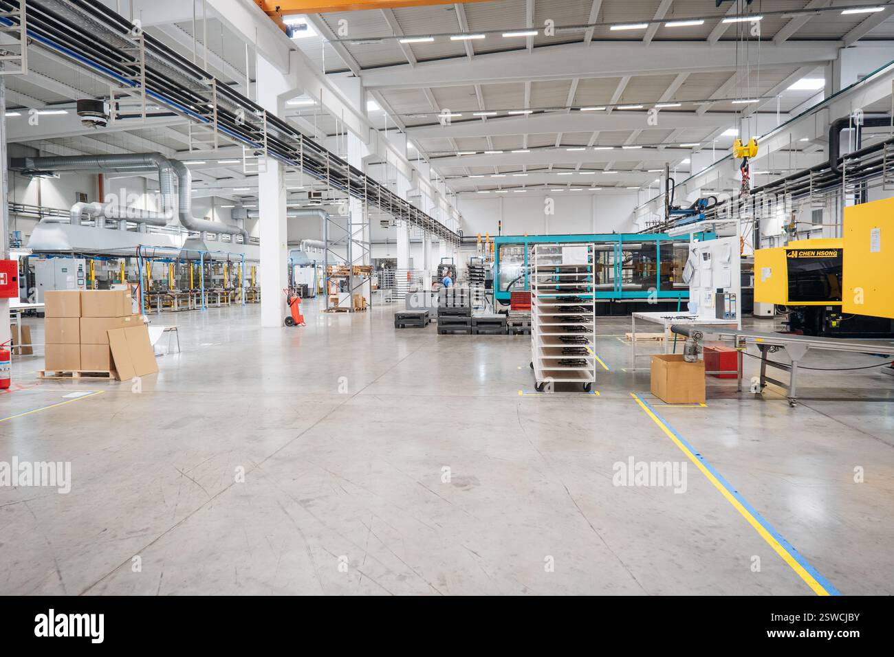 Spacious factory floor with equipment and supplies ready for industrial ...