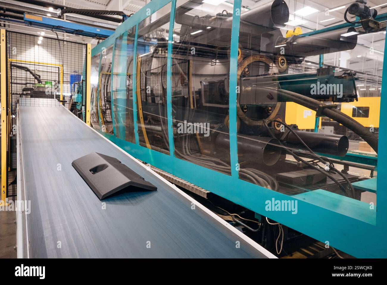Industrial plastic part on a conveyor belt after the molding process ...