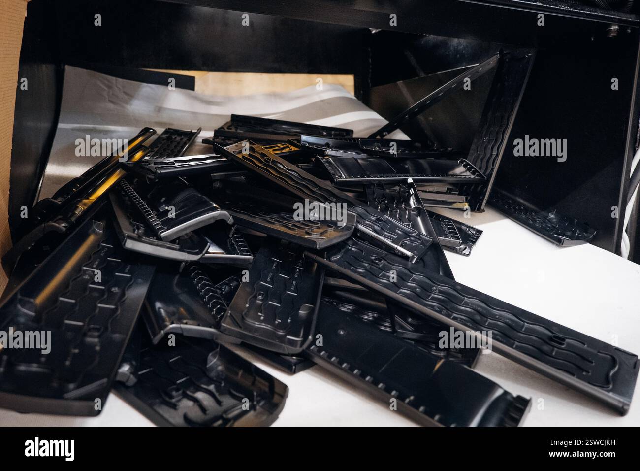 Pile of Black Plastic: A heap of dark reflective plastic pieces in ...