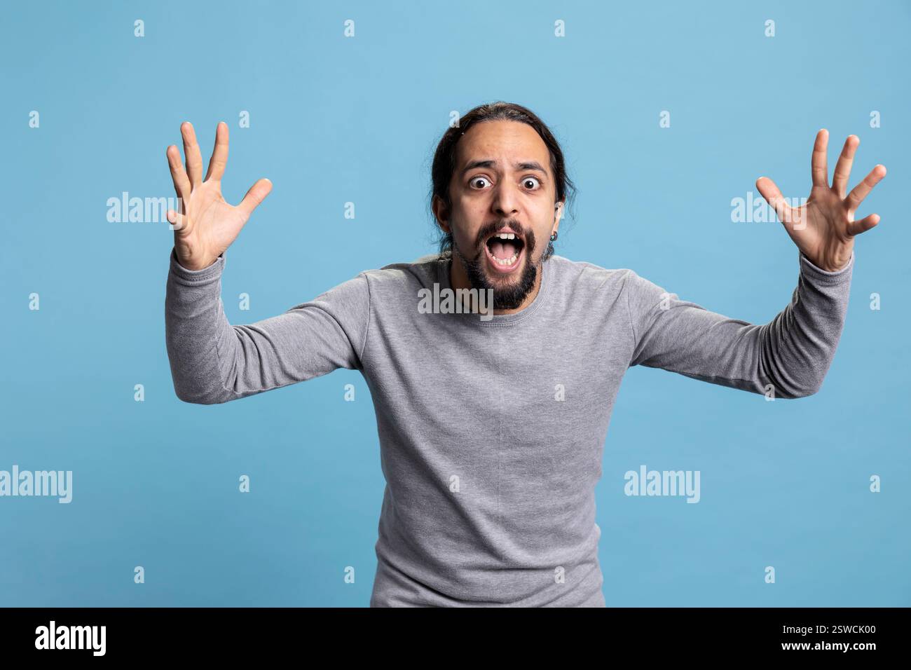 Furious irritated man yelling and acting aggressive against blue ...