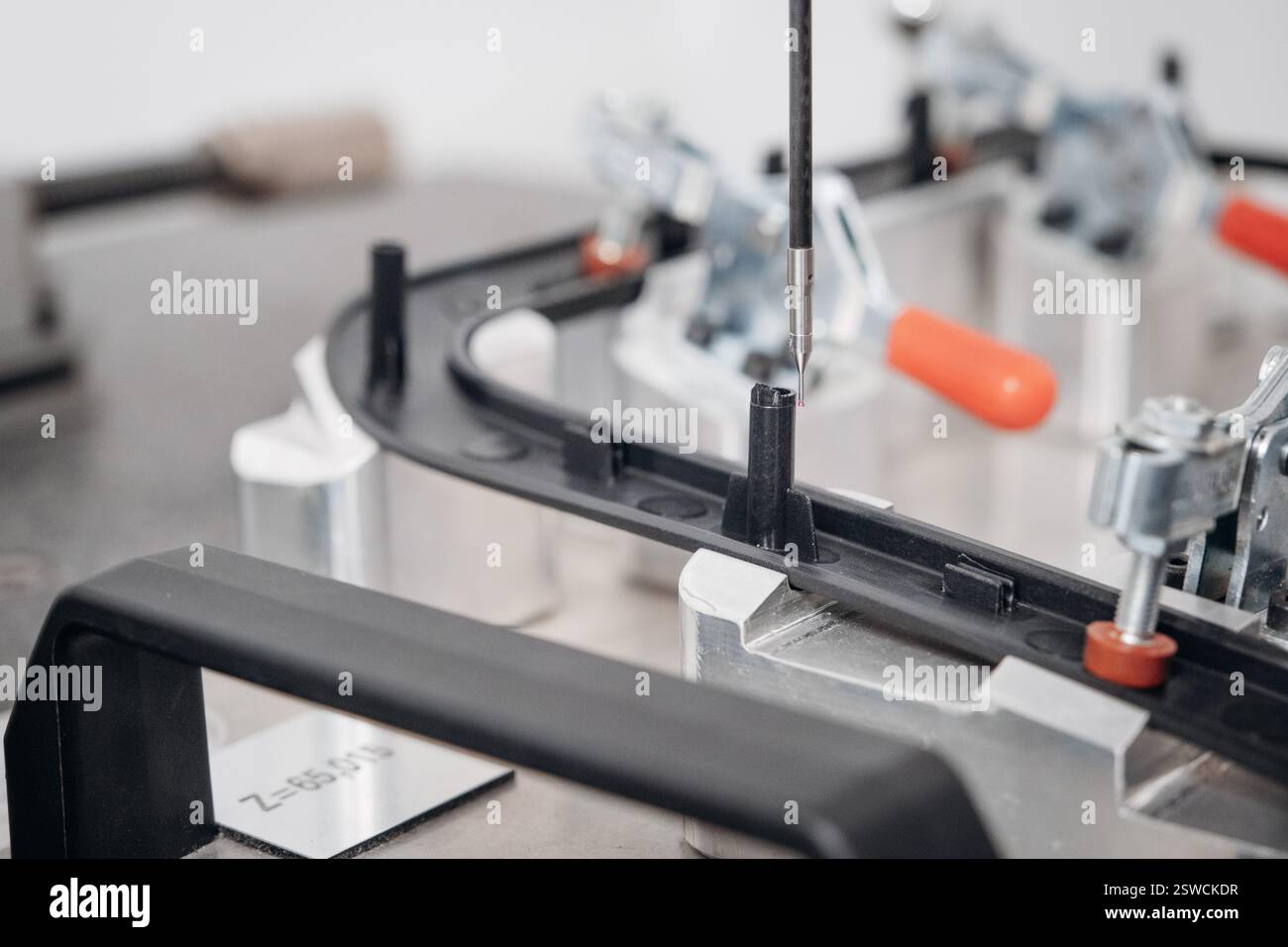 Precision Measurement: Gauge measuring a black molded part on a metal ...