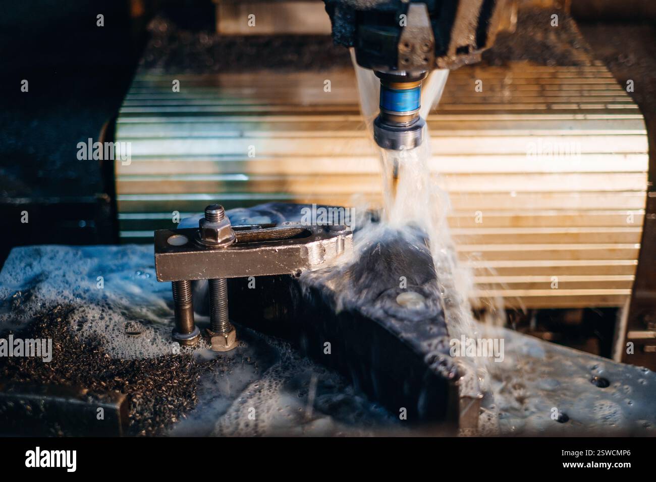 Automated metal milling using coolants shaping a dark metal piece in an ...