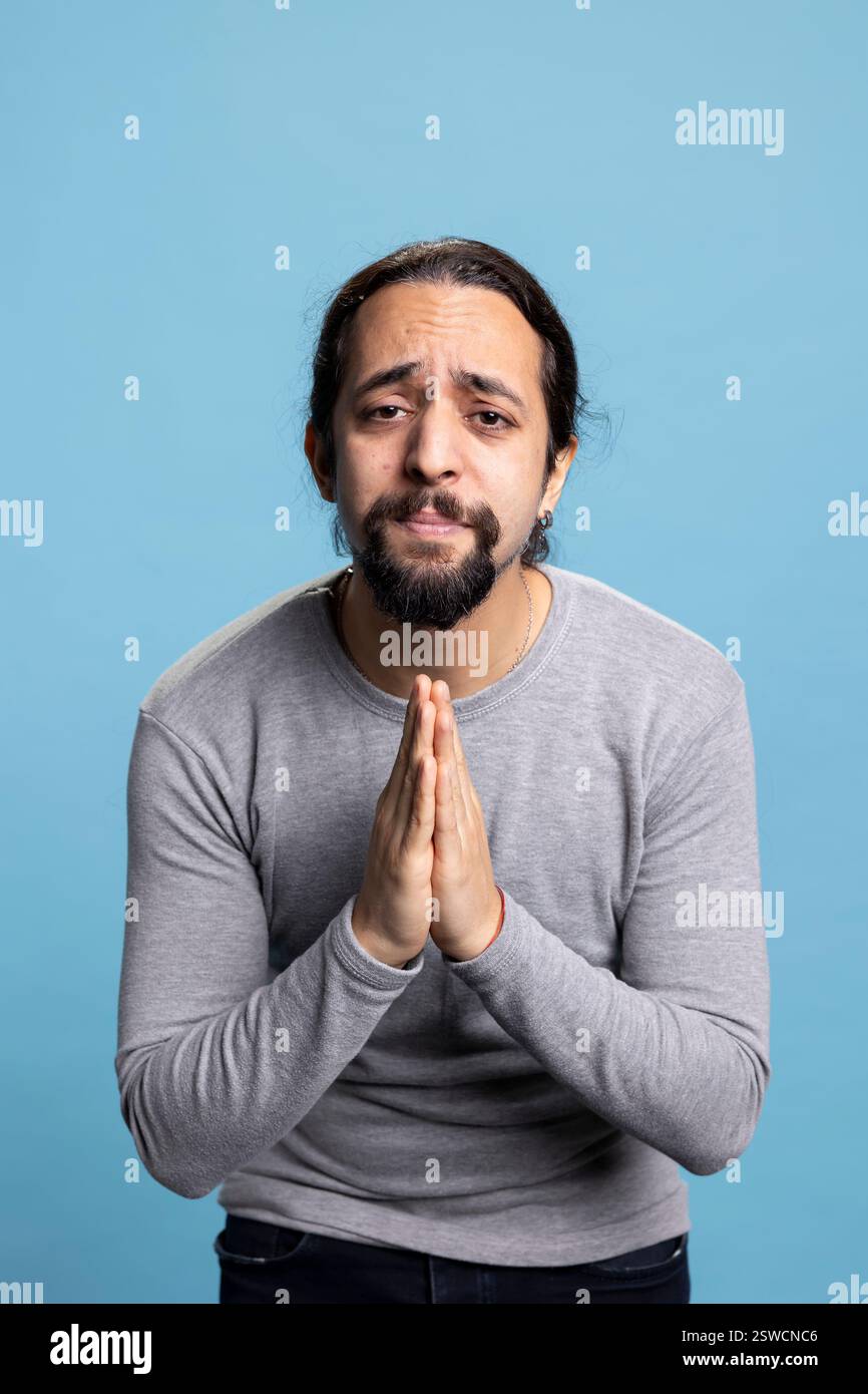 Male person posing with his hands in a prayer and worshipping God on ...