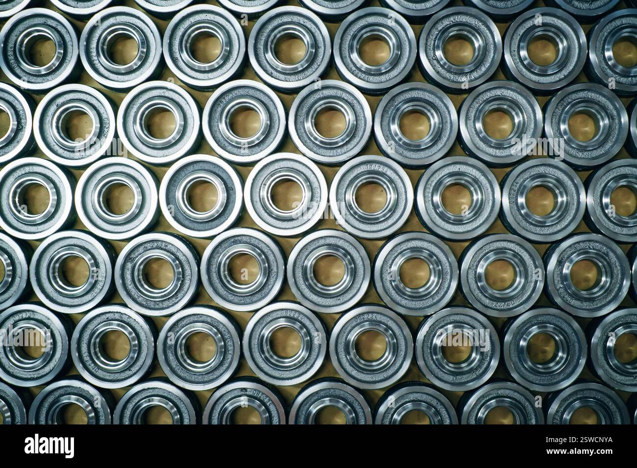 Shiny metal bearings aligned in rows showing precision engineering and ...