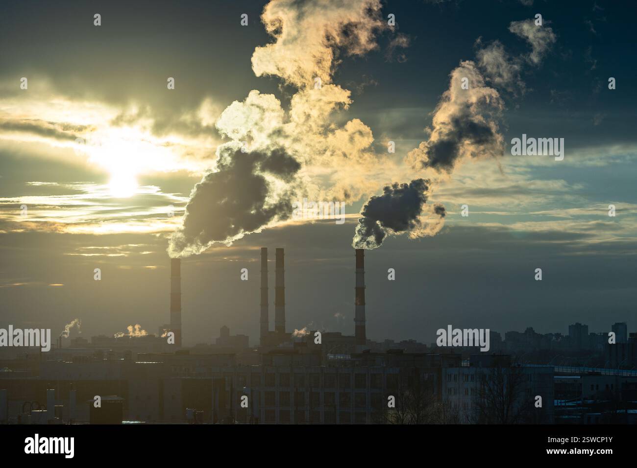 Smoke from factory pipe of heat station in the city in winter time. Air ...