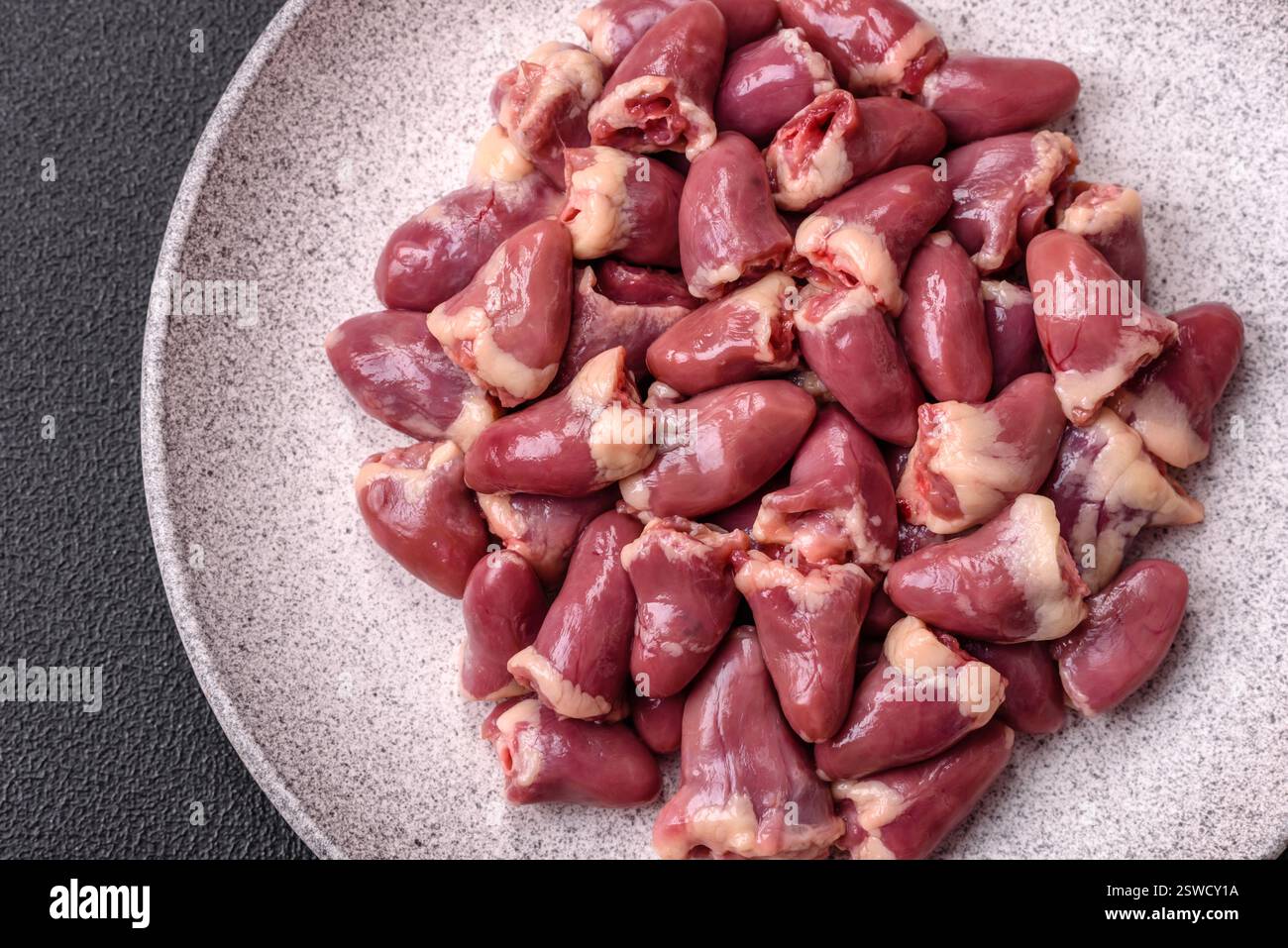 Raw chicken hearts with salt, spices and herbs Stock Photo - Alamy