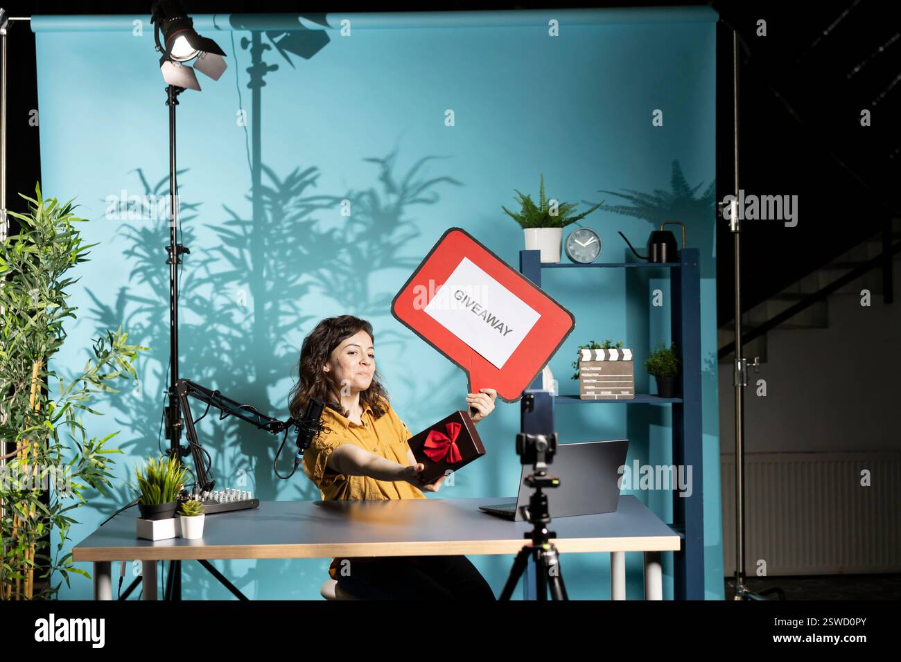 Social media influencer presenting giveaway for audience, holding gift ...