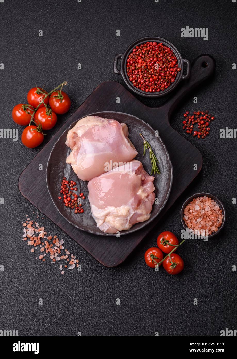 Fresh raw chicken thigh fillets with salt, spices and herbs Stock Photo ...