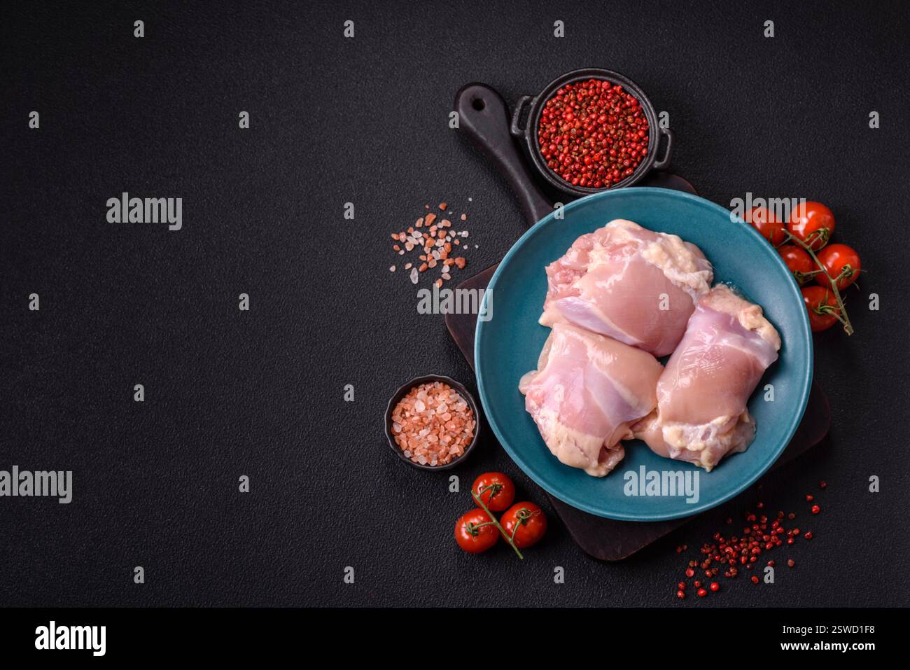 Fresh raw chicken thigh fillets with salt, spices and herbs Stock Photo ...