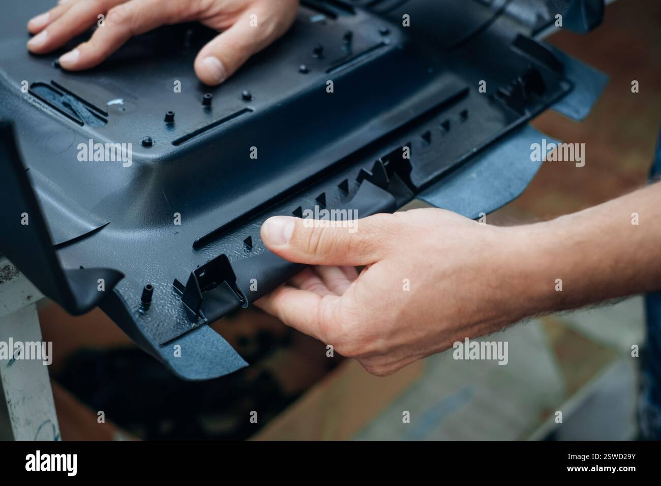 Handling a molded plastic component with visible fastening points and ...