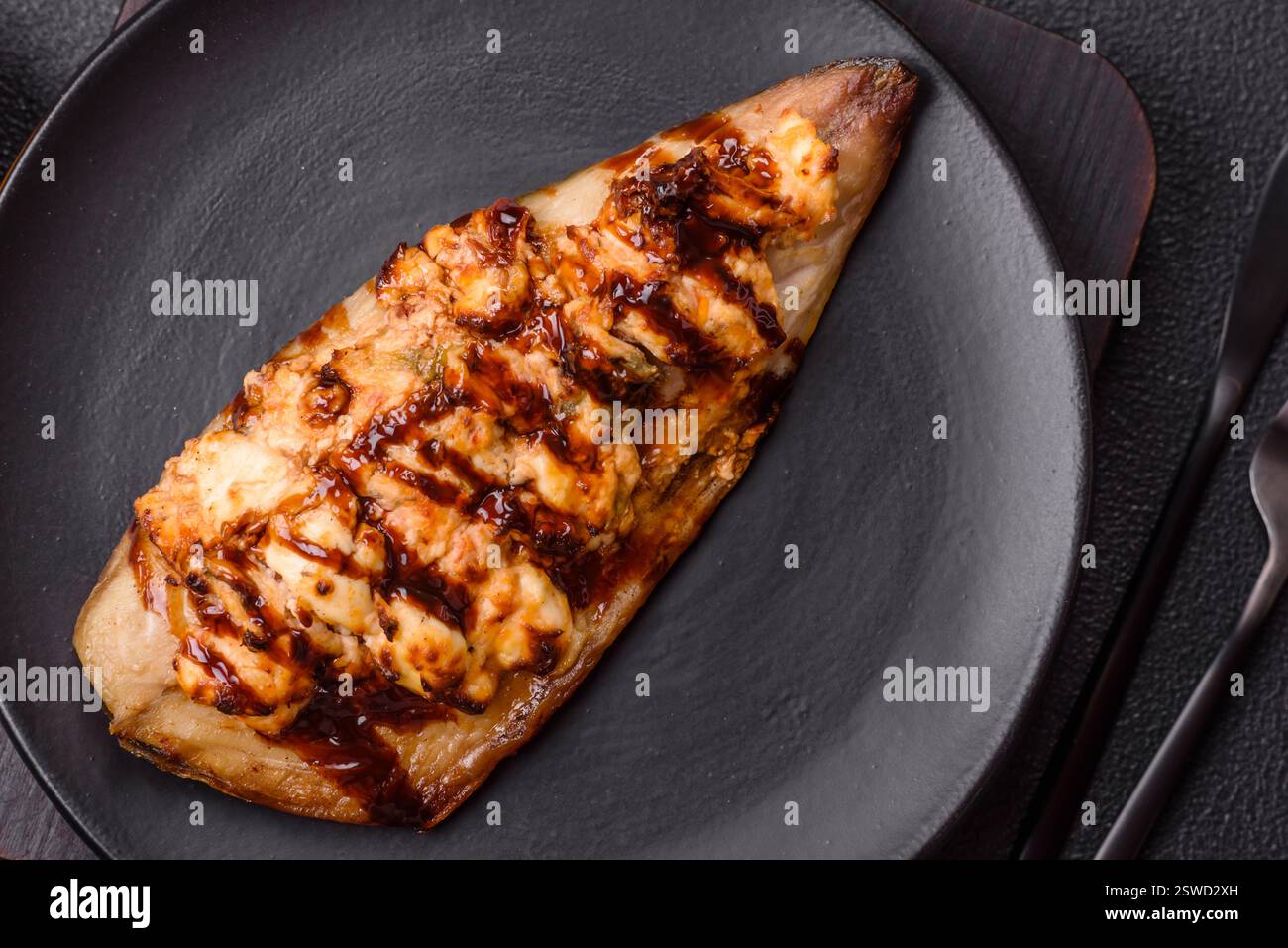 Grilled mackerel fillets with cheese, salt, spices and herbs on dark ...
