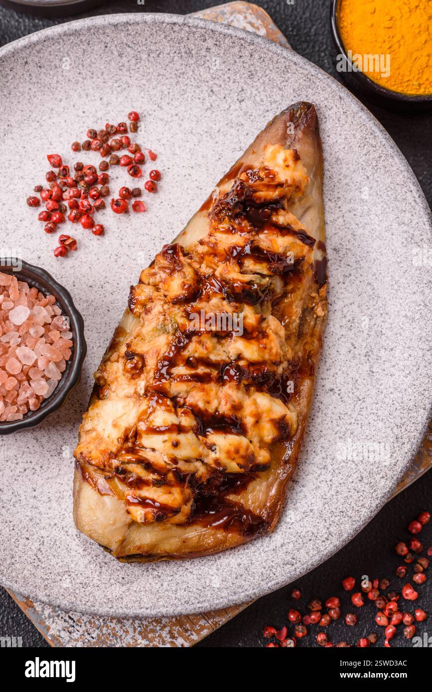 Grilled mackerel fillets with cheese, salt, spices and herbs on dark ...