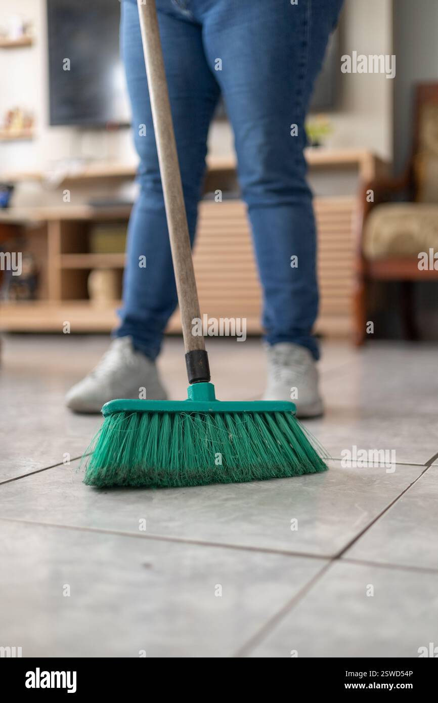 A woman sweeping the floor, seen from the waist down, perfect for ...