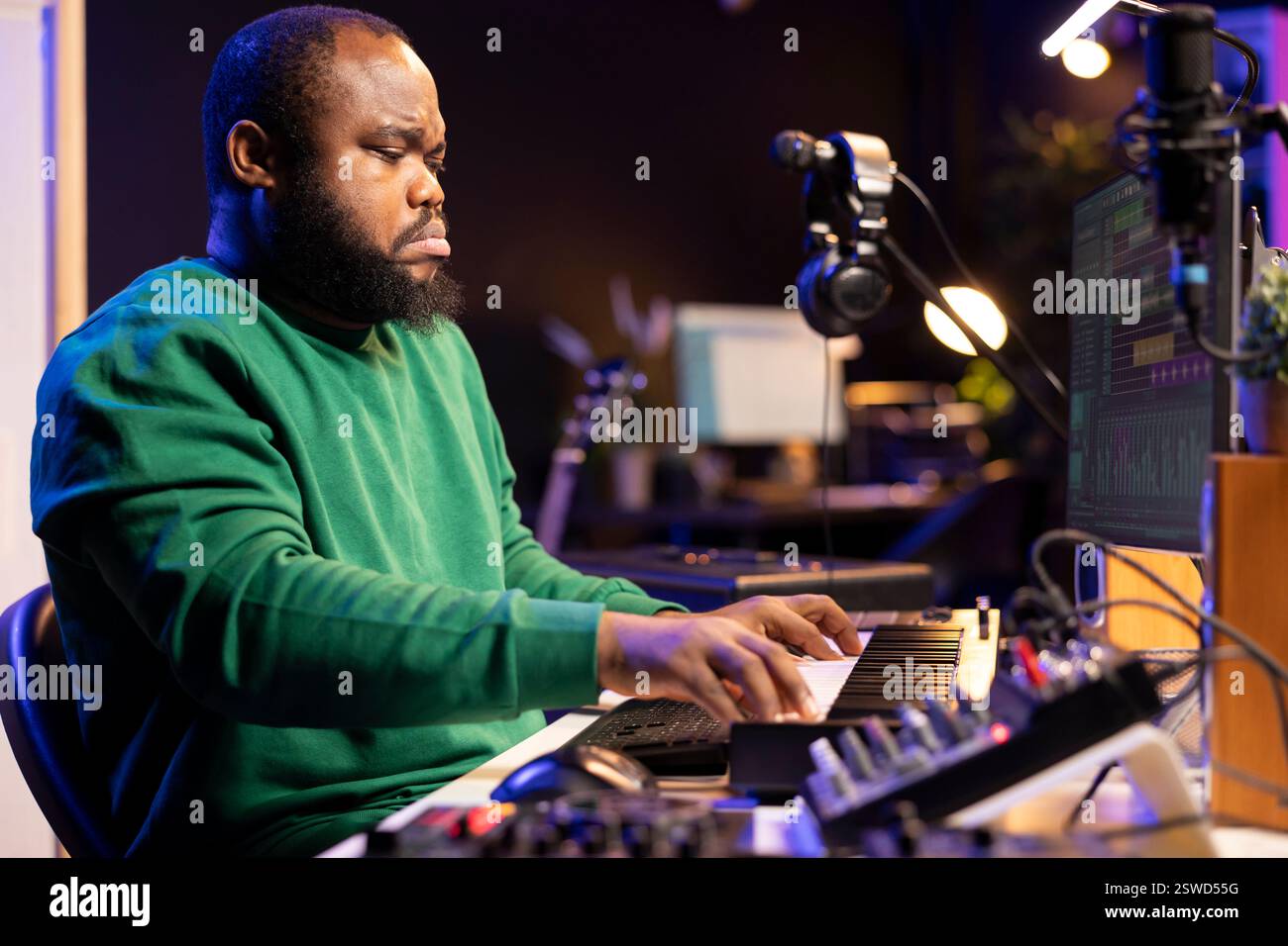 African american audio technician using piano synthesizer keys to add ...