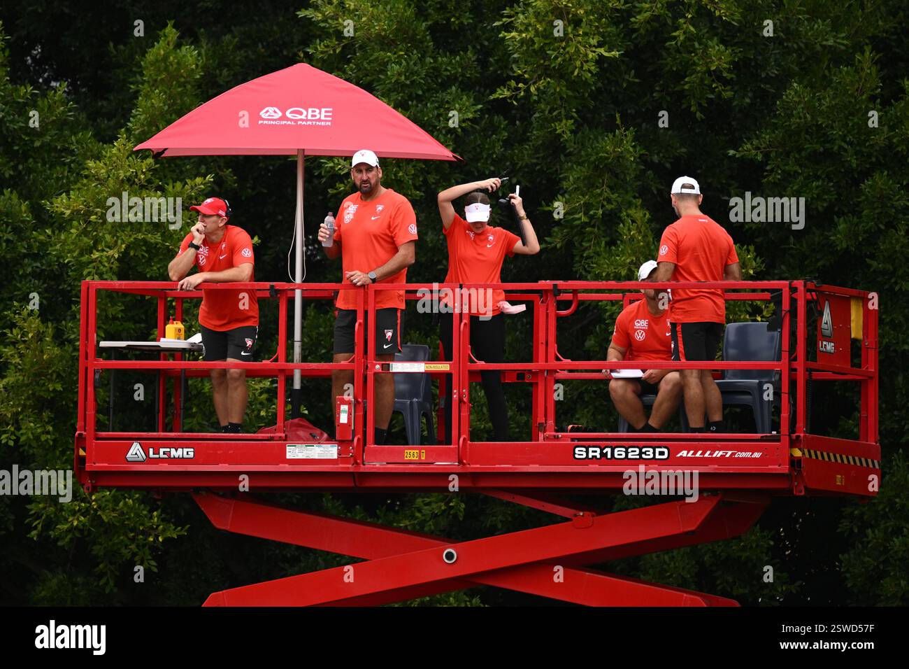 Swans head coach Dean Cox (second left) watches on from a scissor lift ...