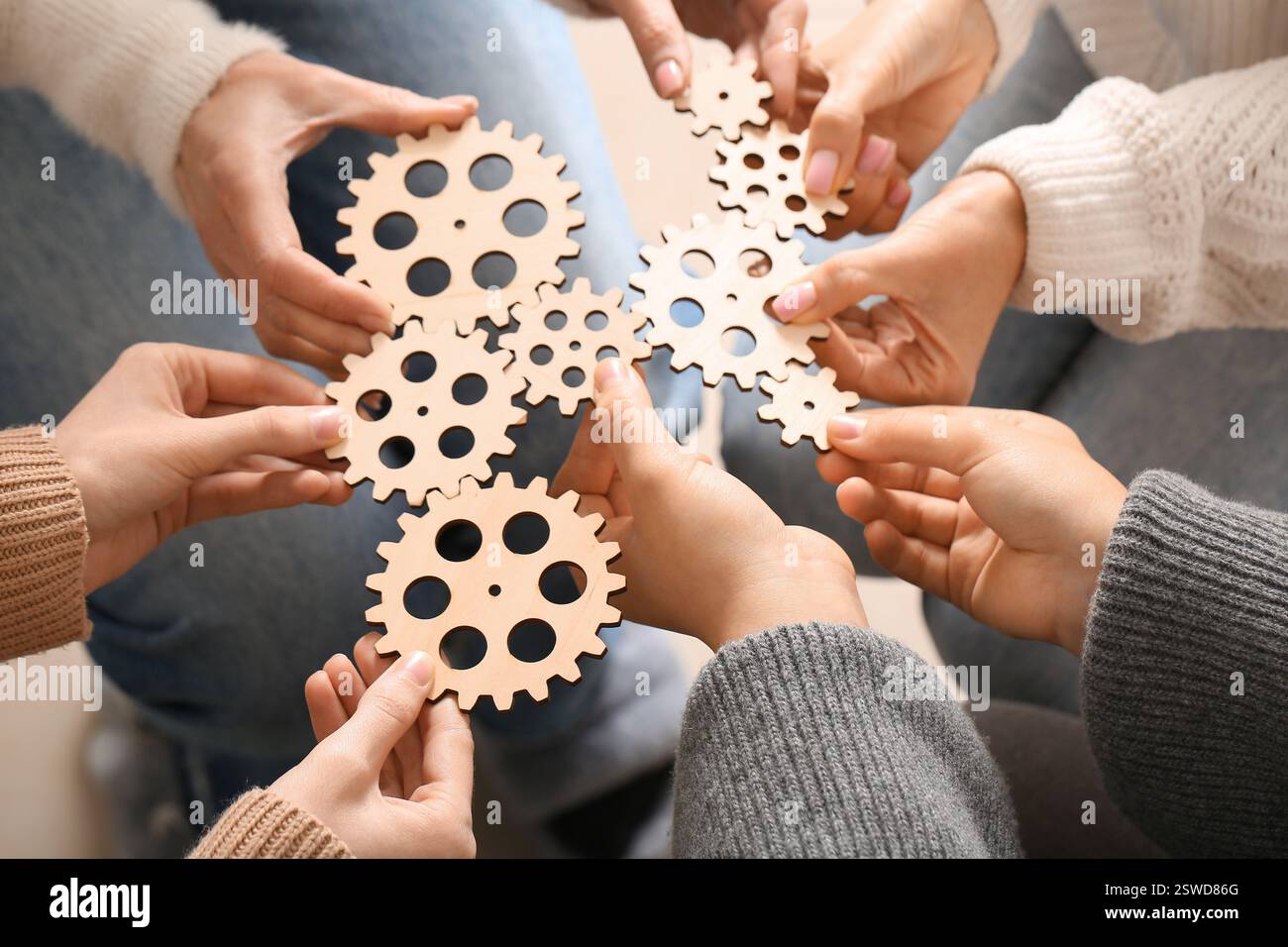 Group of people holding wooden gears Stock Photo - Alamy