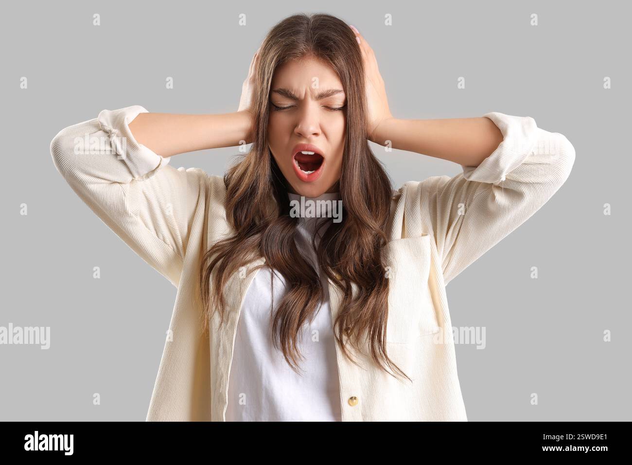 Screaming young woman having panic attack on light background Stock ...