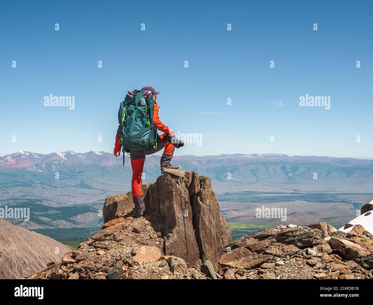Photographer with a large backpack on the edge of a cliff. Dangerous ...