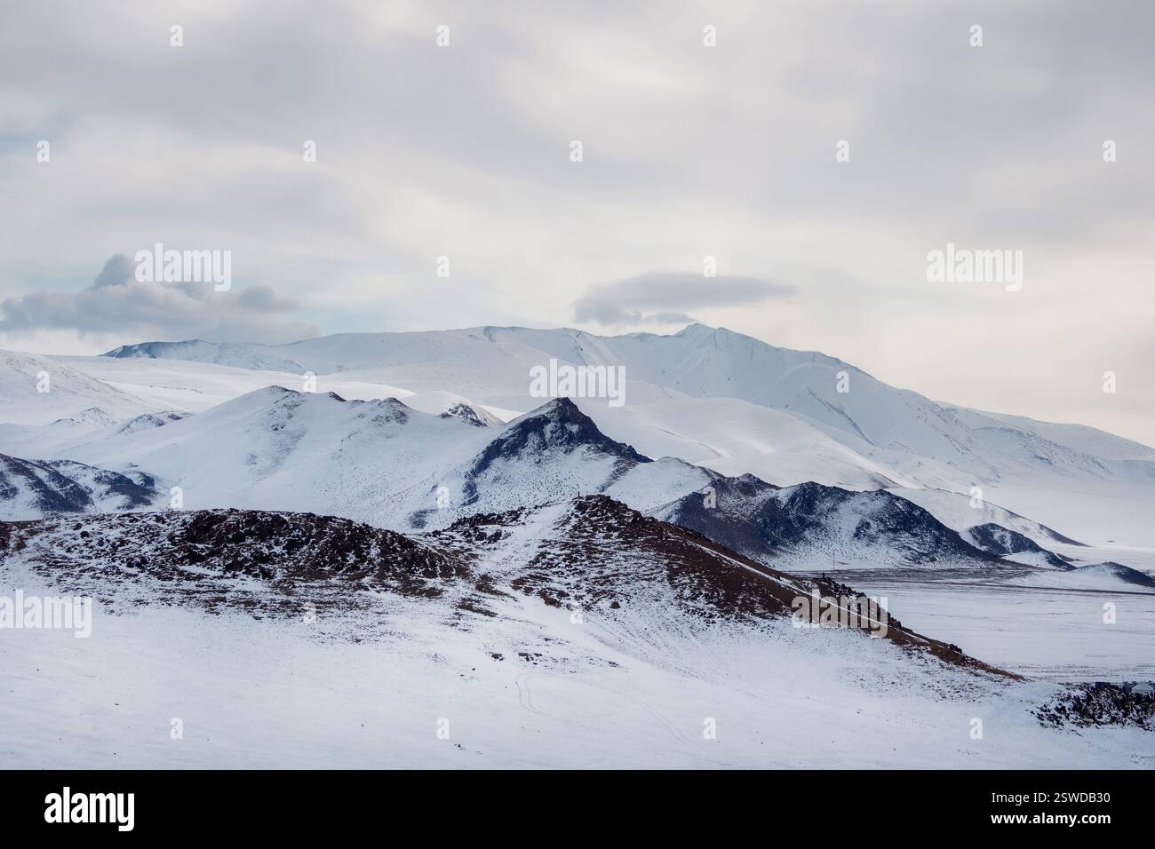 Cold snow-white landscape of snowy valley. Snow-covered rocky mountain ...