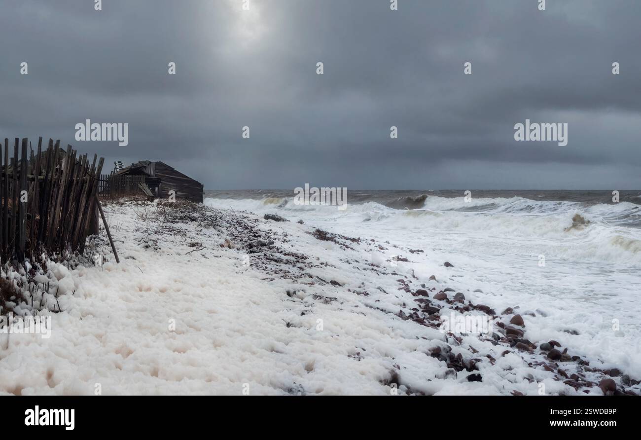 Dramatic seascape with a raging sea and a fishing hut on the shore ...