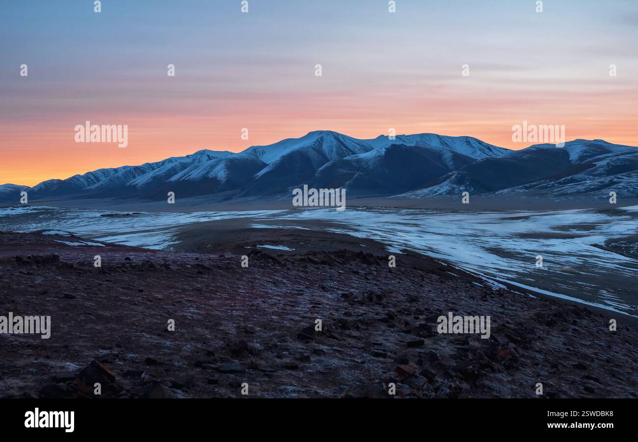 Panoramic mountain landscape with long snowy mountain range lit by dawn ...