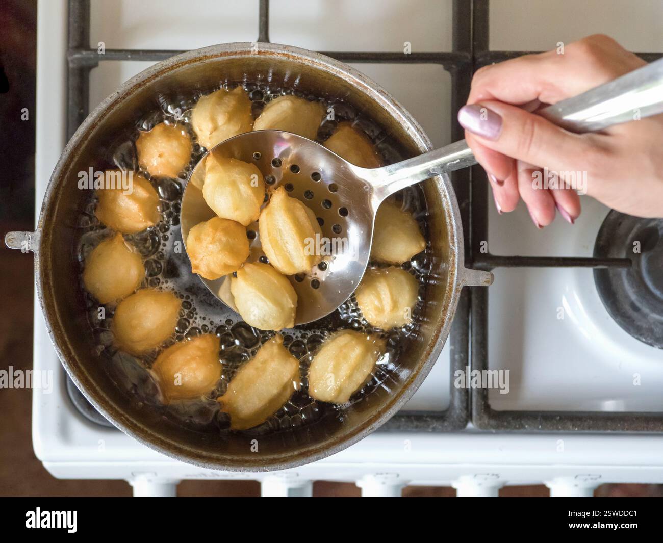 Preparation of Arabic dessert Tulumba in boiling oil. Tulumba - arabian ...