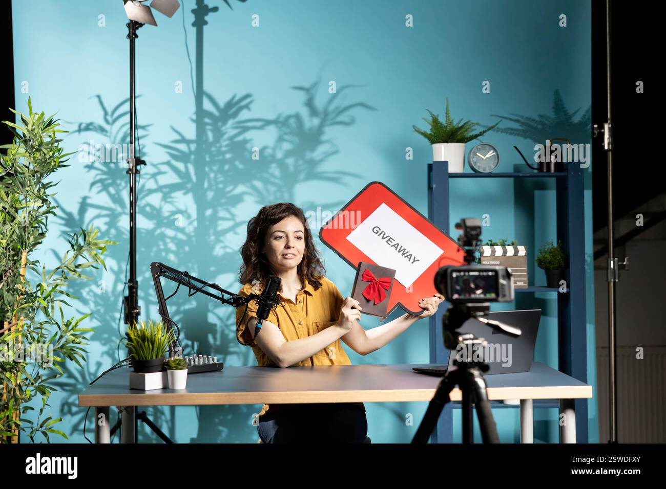 Social media influencer presenting giveaway for audience, holding gift ...