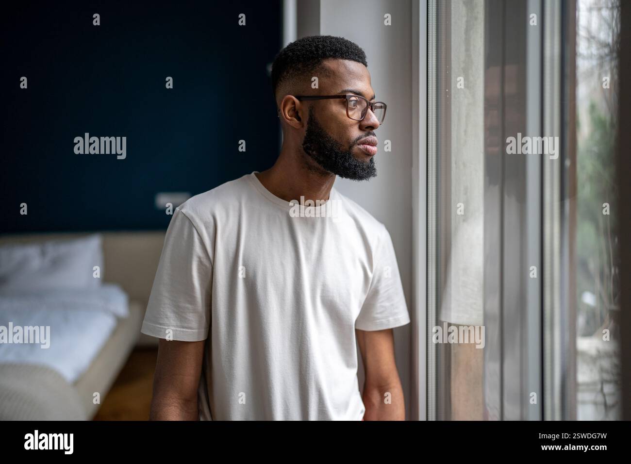 Sad Black man looking out of window thinking about life problems ...
