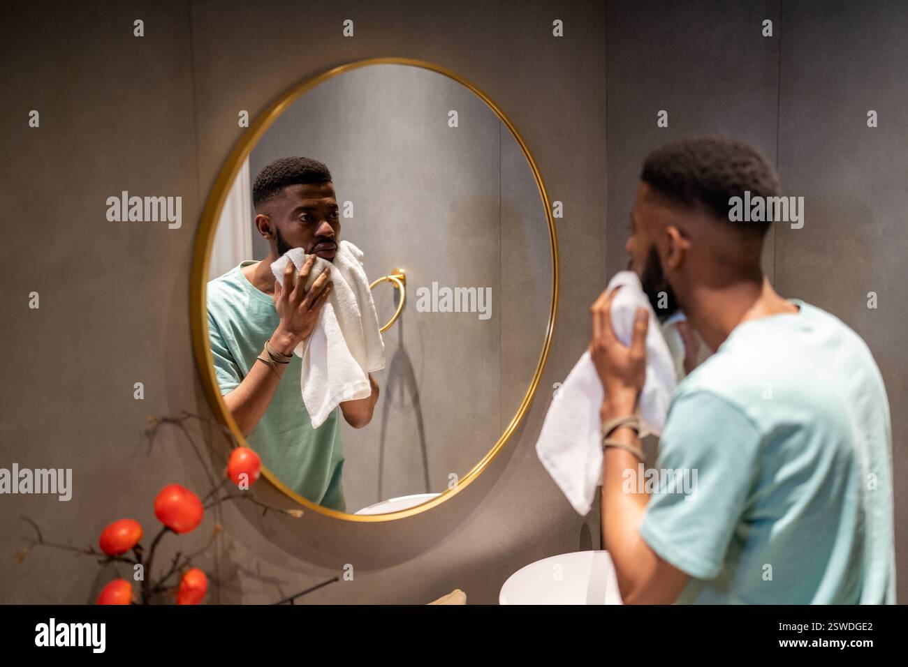 Displeased young african ethnic man wipes face after washing. Male ...