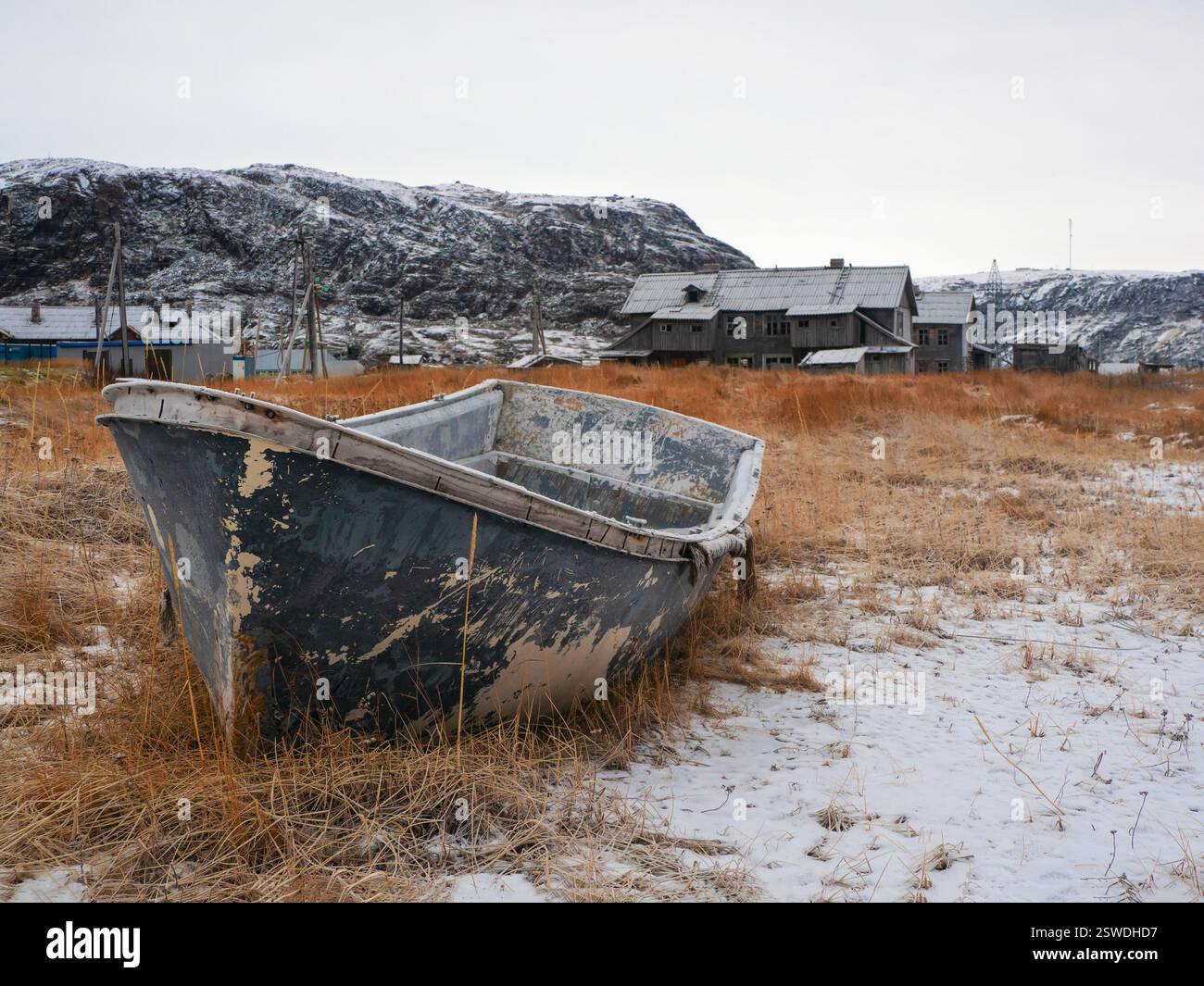 A rusty frozen fishing boat. Old fishing village on the shore of the ...