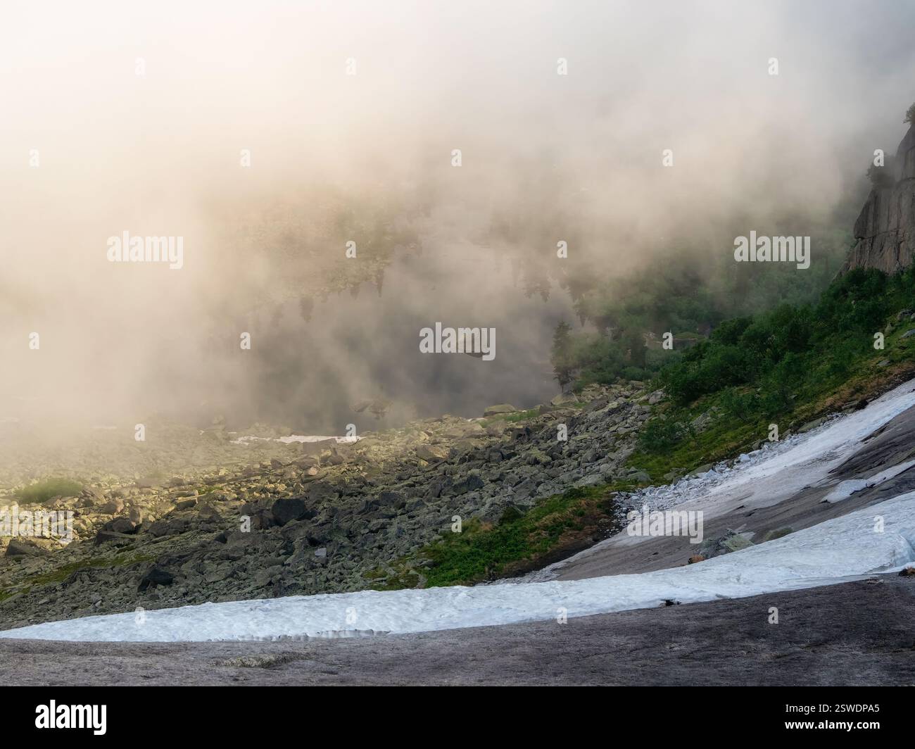 View of the mountain valley through the fog in sunrise. Mountain ridge ...