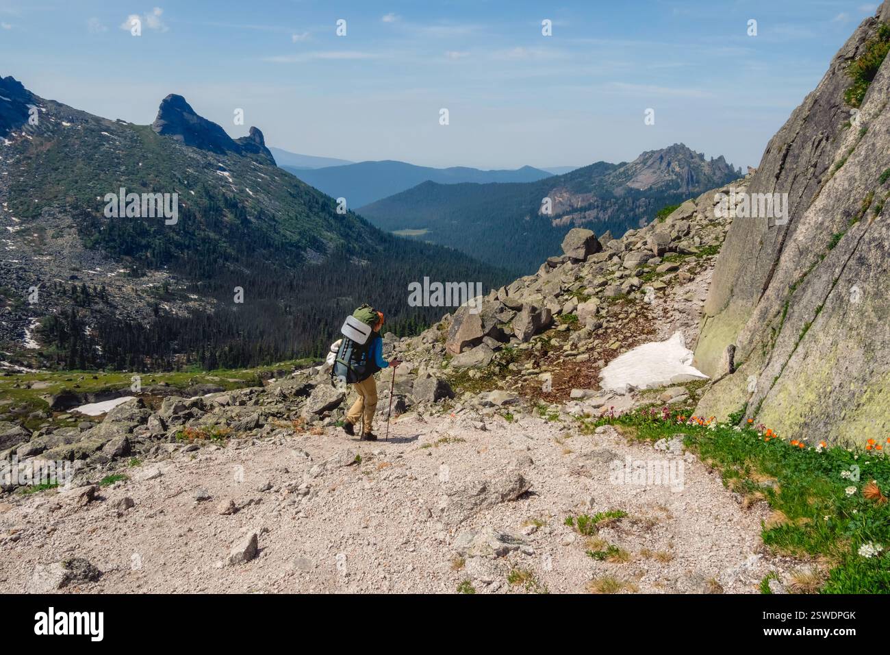 Heavy uphill climb with a big backpack. View of a mountain valley Stock Photo - Alamy