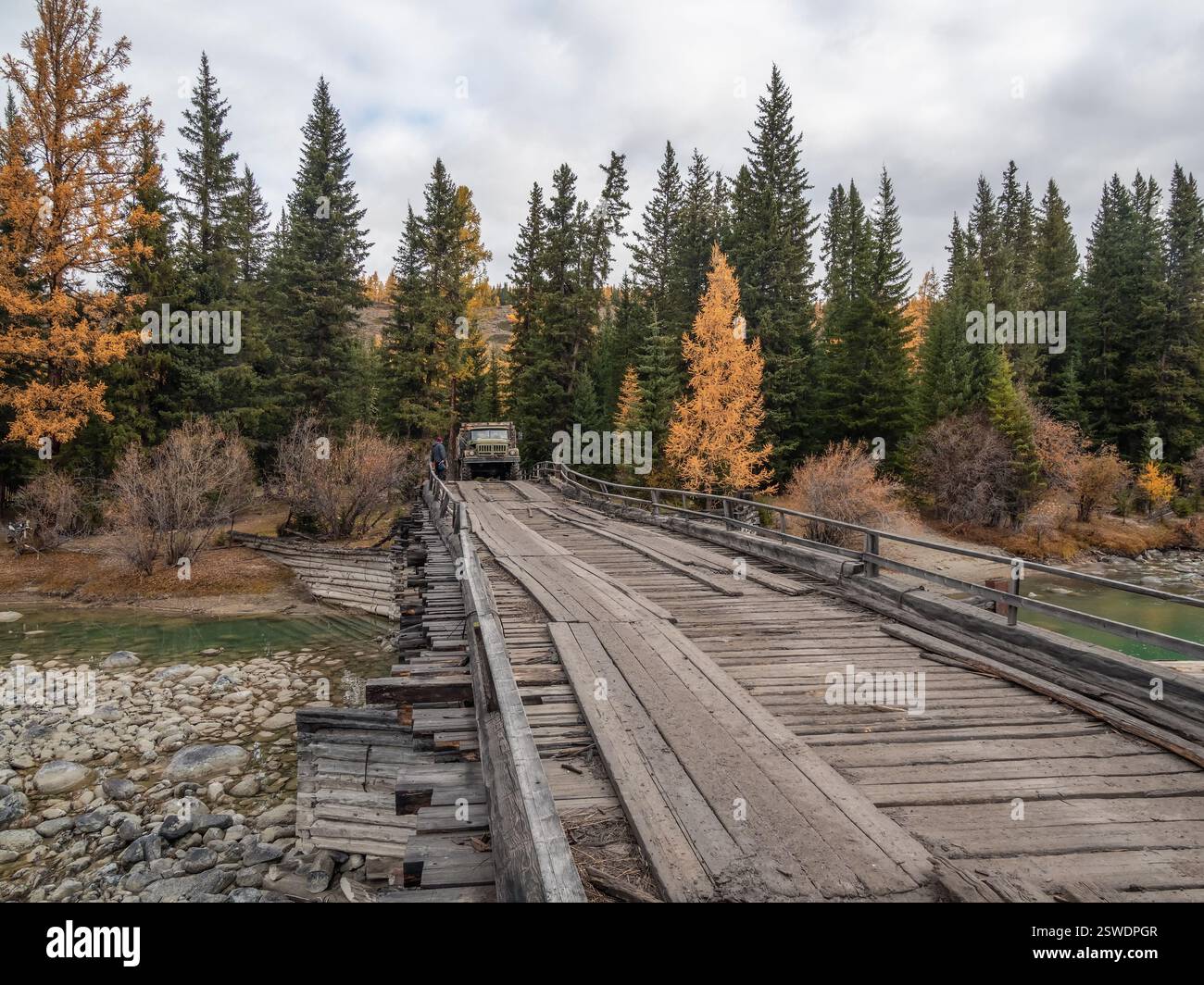 Old truck driving on a dilapidated bridge over a river Stock Photo - Alamy