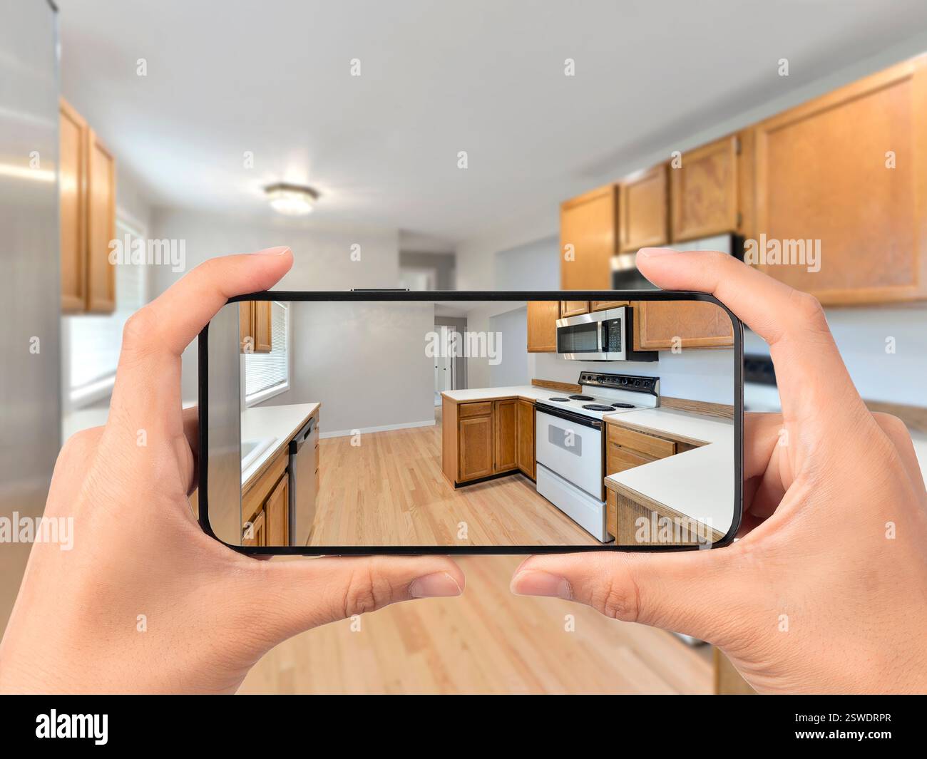 Person taking a photo of a modern residential kitchen interior with a ...