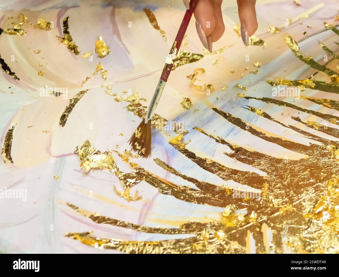 Handmade technique of applying the gold leaf. Gold gilding leaf ...