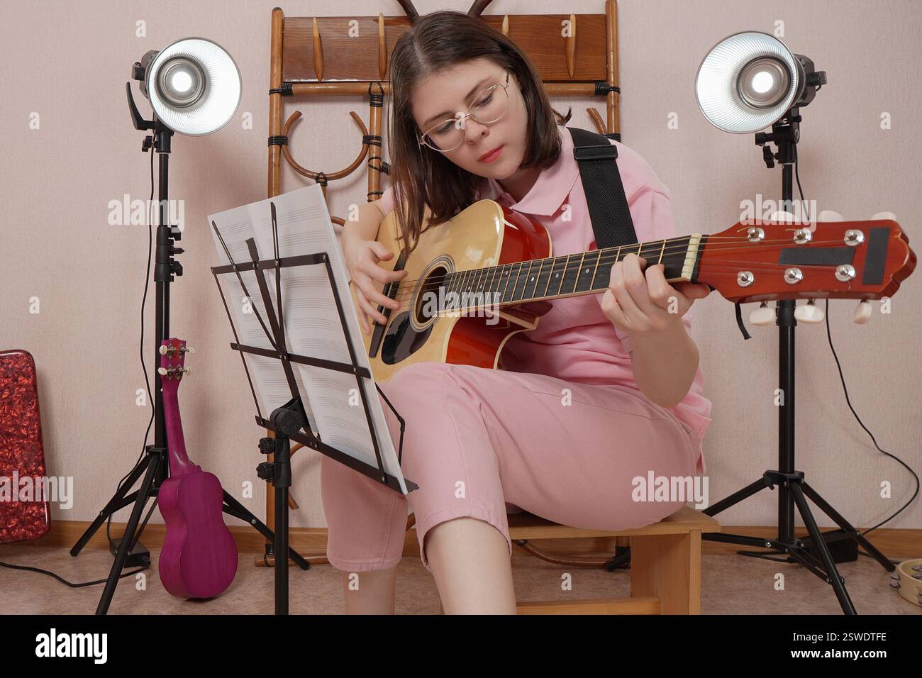 Young woman practicing skill of playing acoustic six string guitar with ...