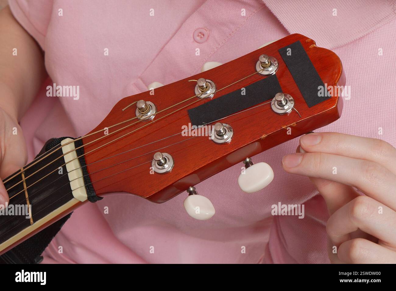 Extreme closeup of woman's fingers as she is tuning Spanish six string ...