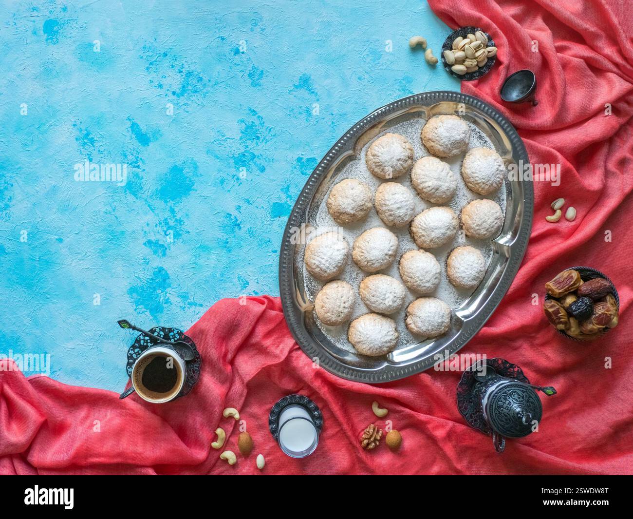 Festive Ramadan sweets are served with tea on the blue table. Egyptian ...