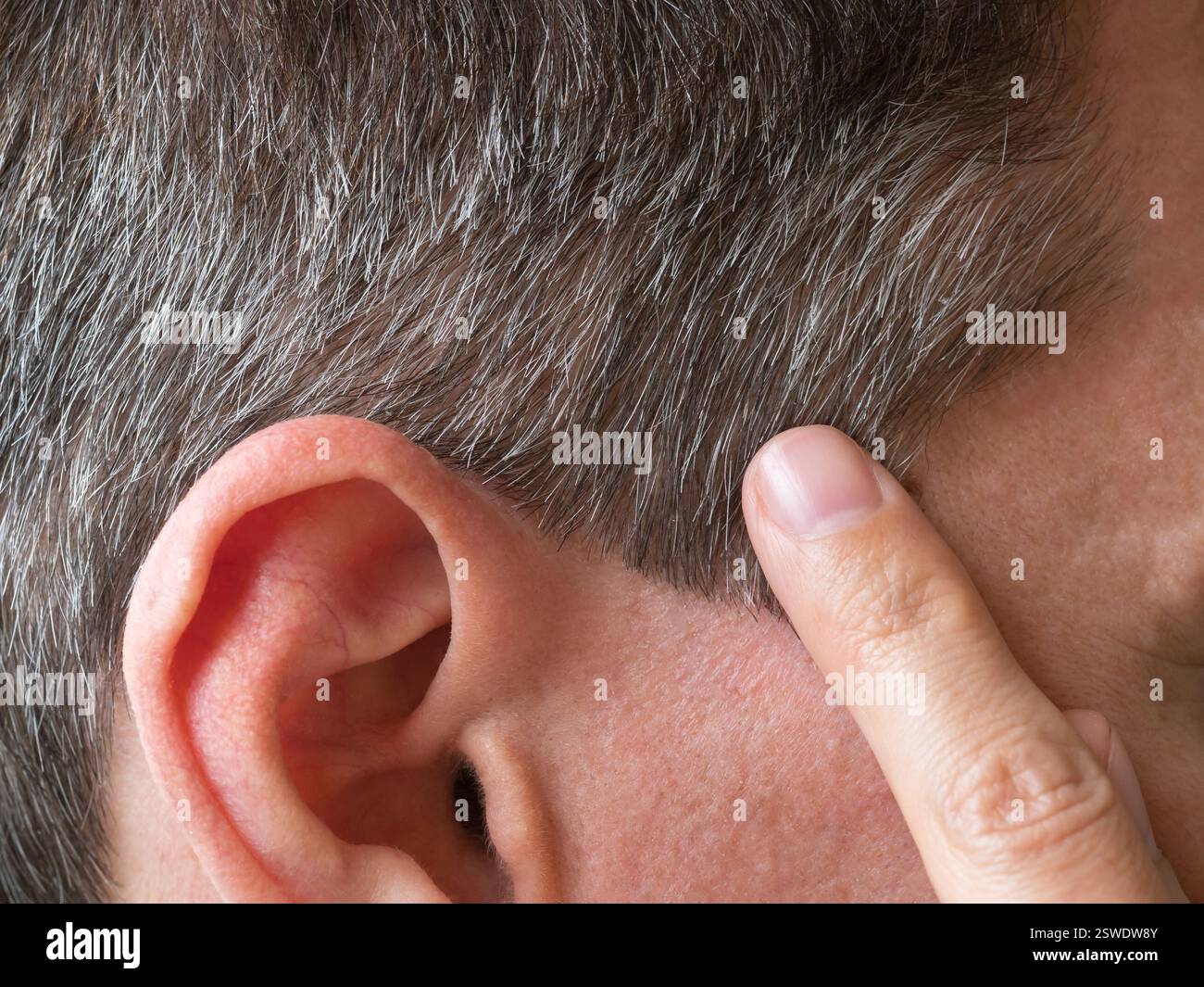 A finger pointing to the gray hair on his head Stock Photo - Alamy
