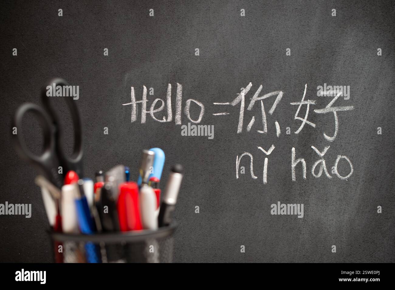 Beginner Chinese language learner writing Hello word Nihao in Chinese ...